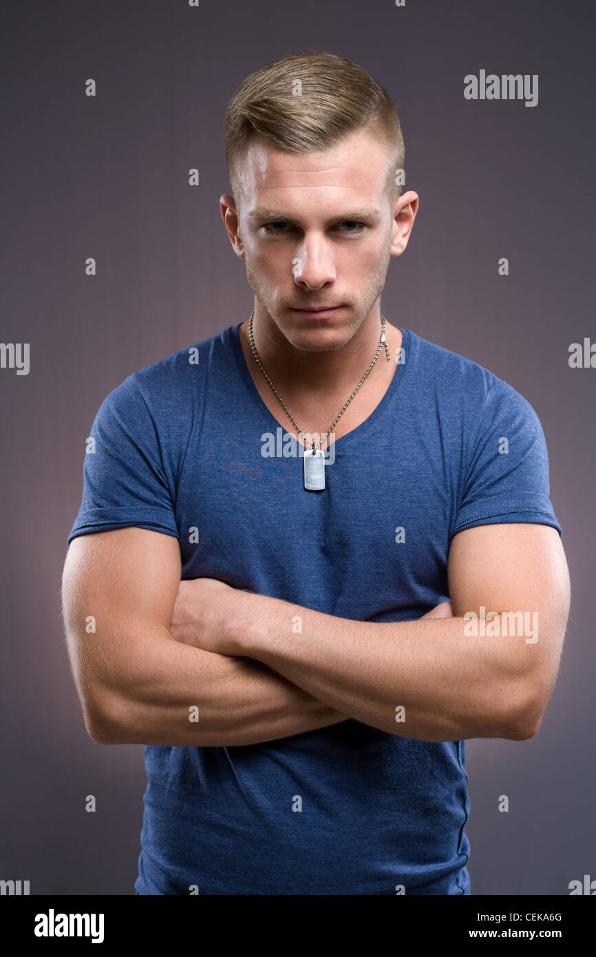 Portrait of masculine tough looking young man with serious expression ...