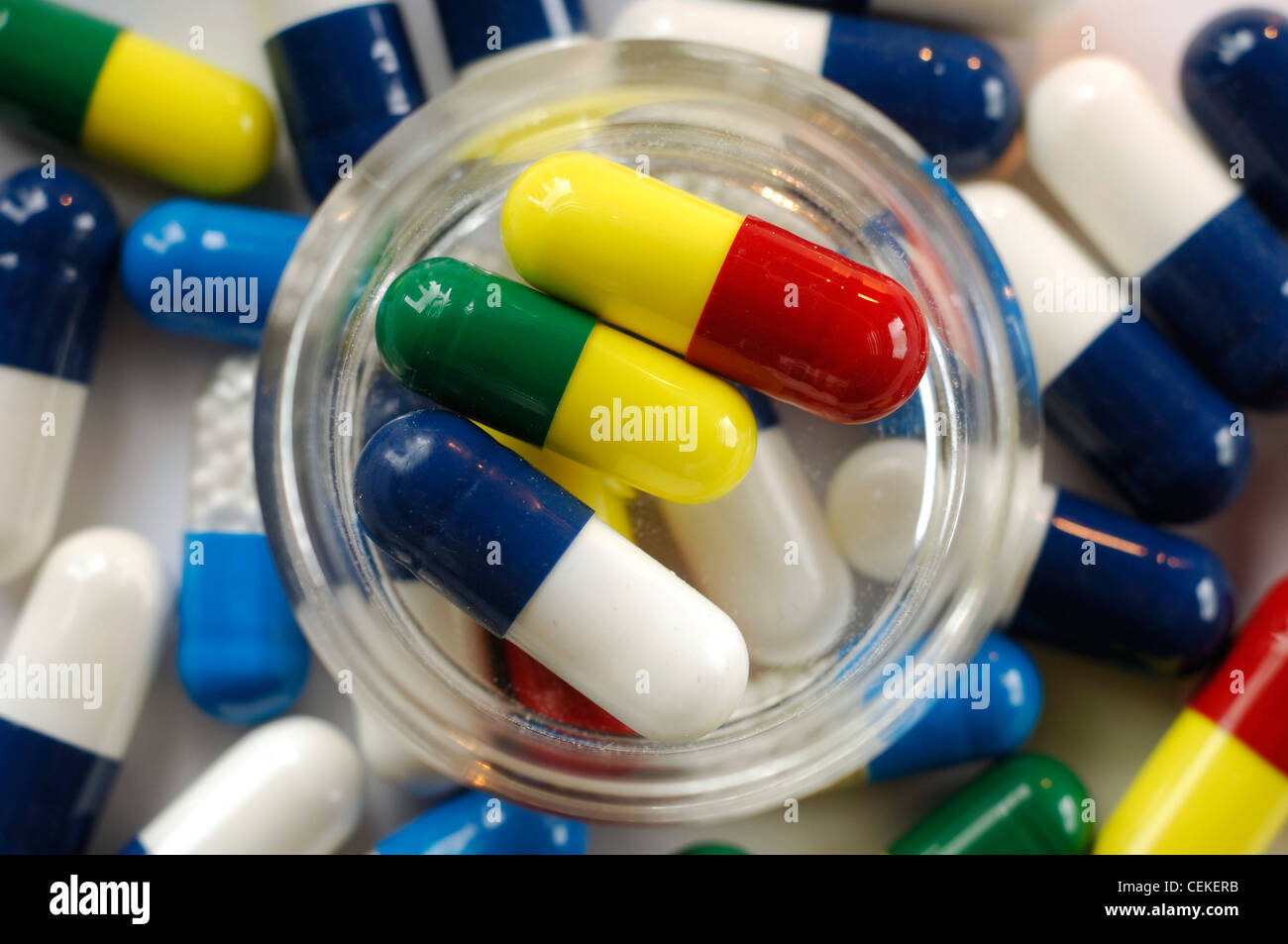 Aerial view of a pot containing capsules of different colours, on top ...