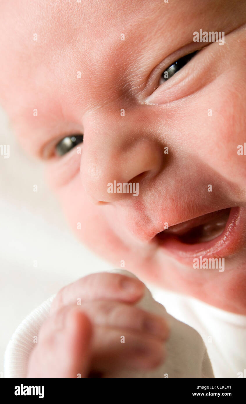 Close up of new born baby crying with hand in front of open mouth Stock ...