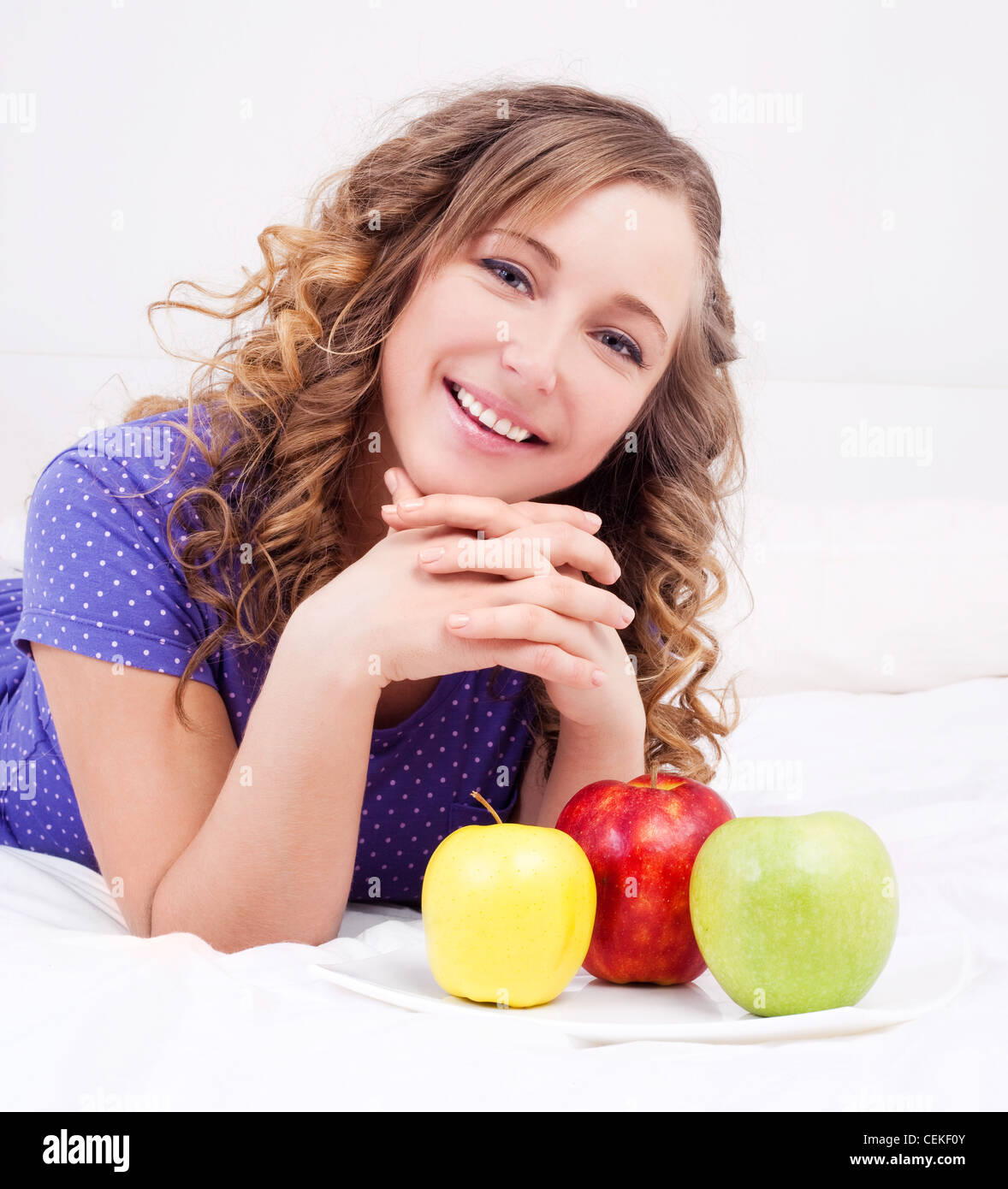 young woman with apples in bed Stock Photo - Alamy