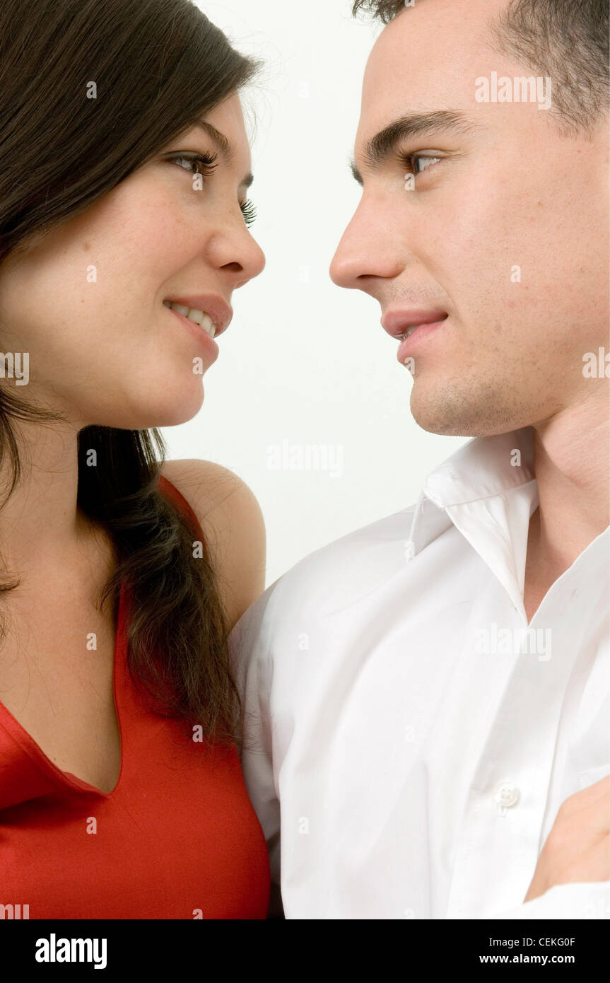 Brunette female and brunette male sitting close together and looking ...
