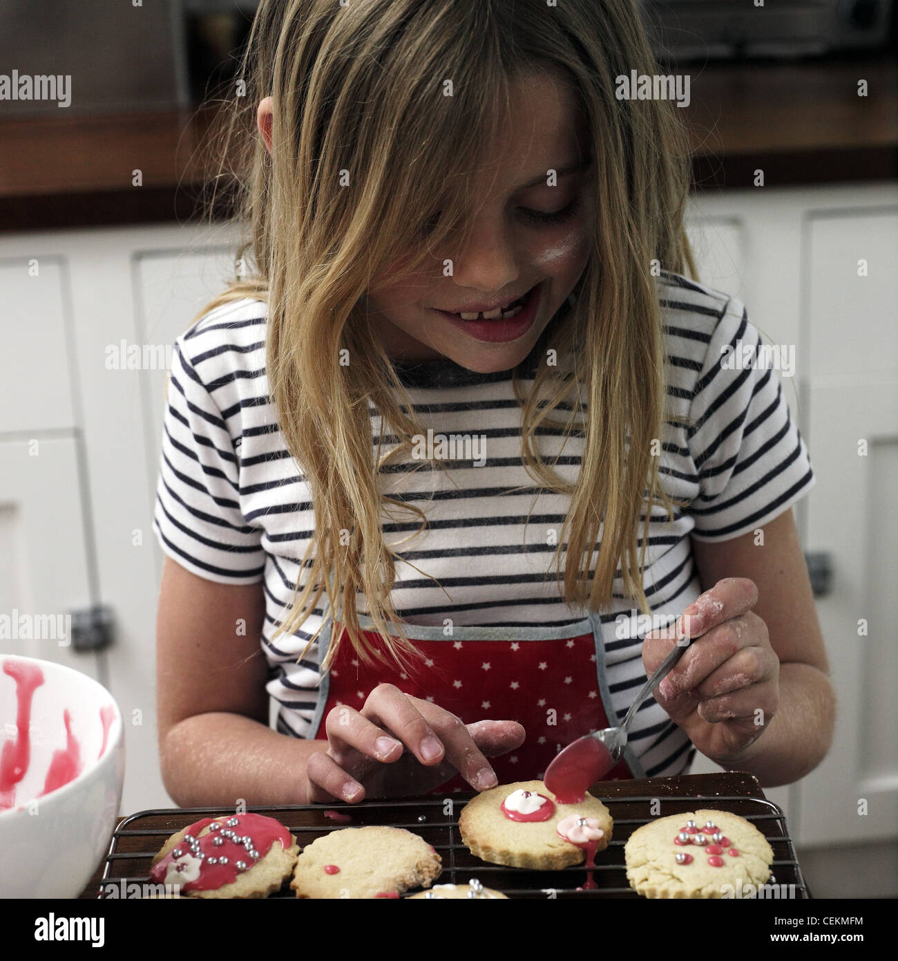 Female child decorating biscuits Stock Photo - Alamy