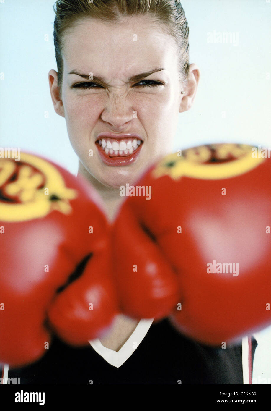 Female with angry facial expression wearing boxing gloves Stock Photo ...