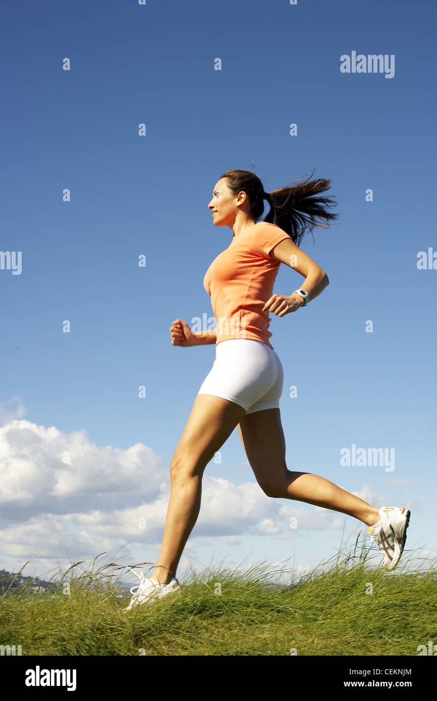 Female very long brunette hair tied into ponytail, wearing an orange t ...