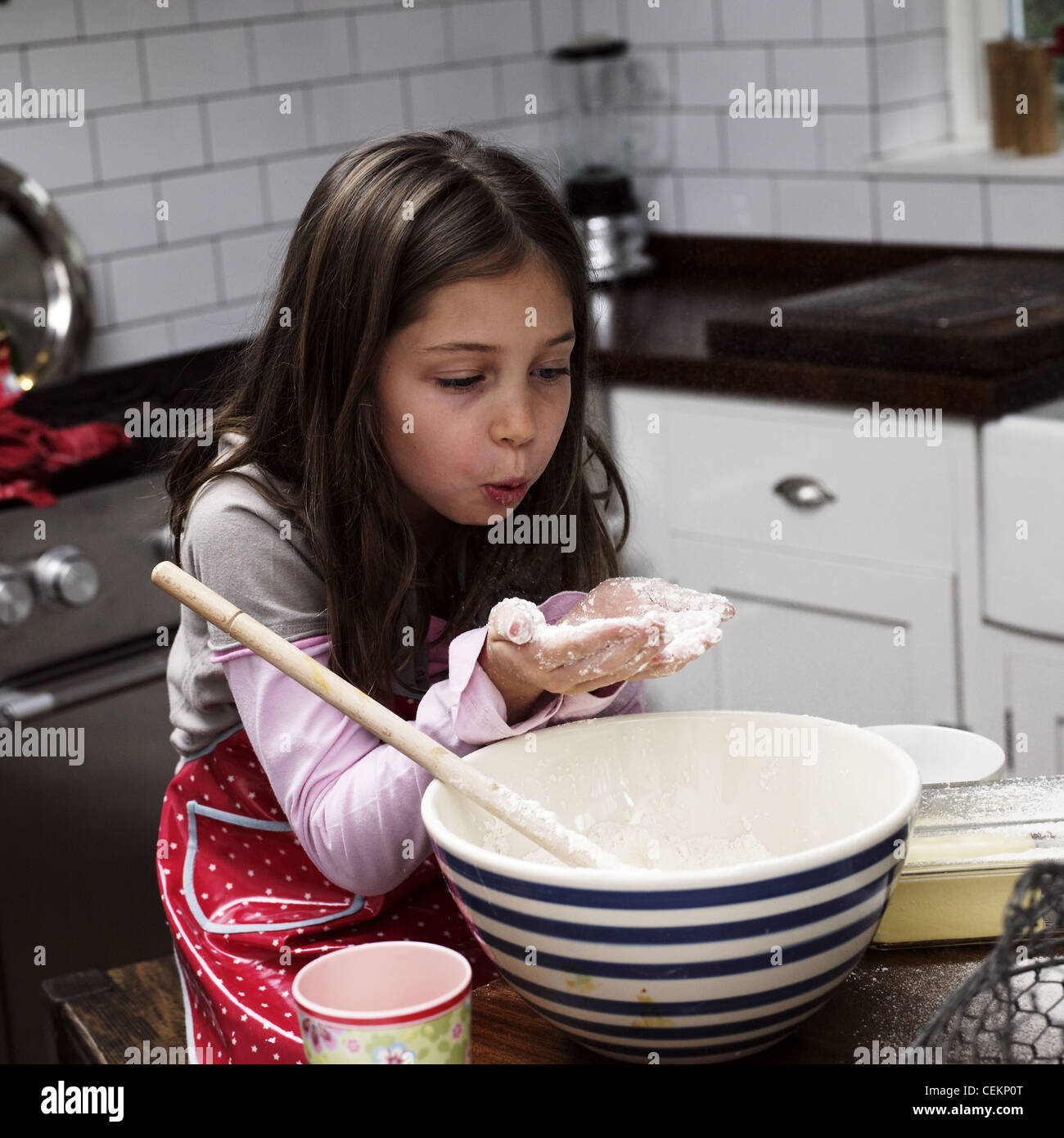Female Child blowing flour from her cupped hands Stock Photo - Alamy