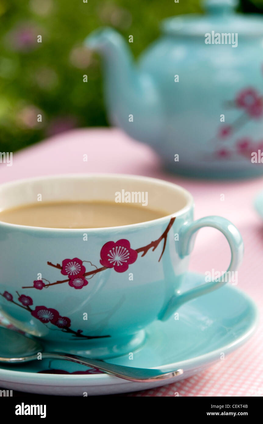 An English cream tea Cup of tea in a blue tea cup and saucer with pink ...