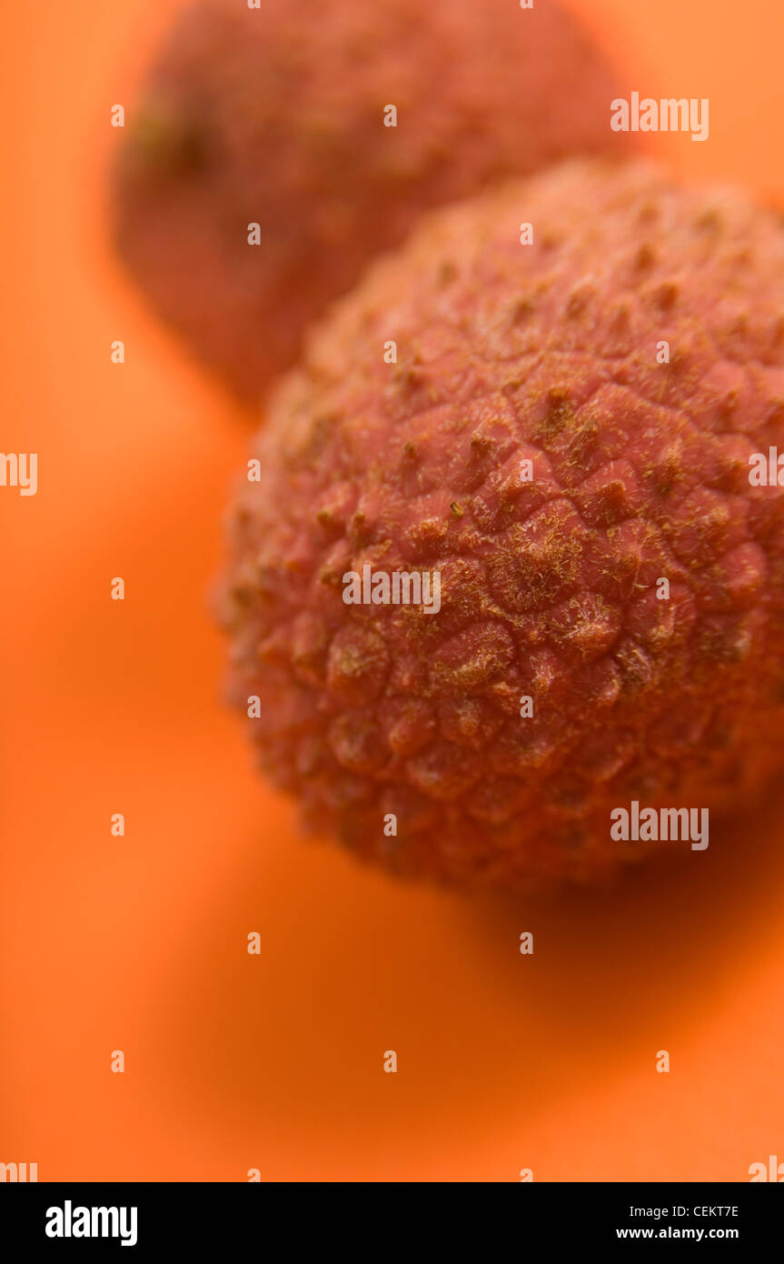 Two lychees on an orange background Stock Photo - Alamy