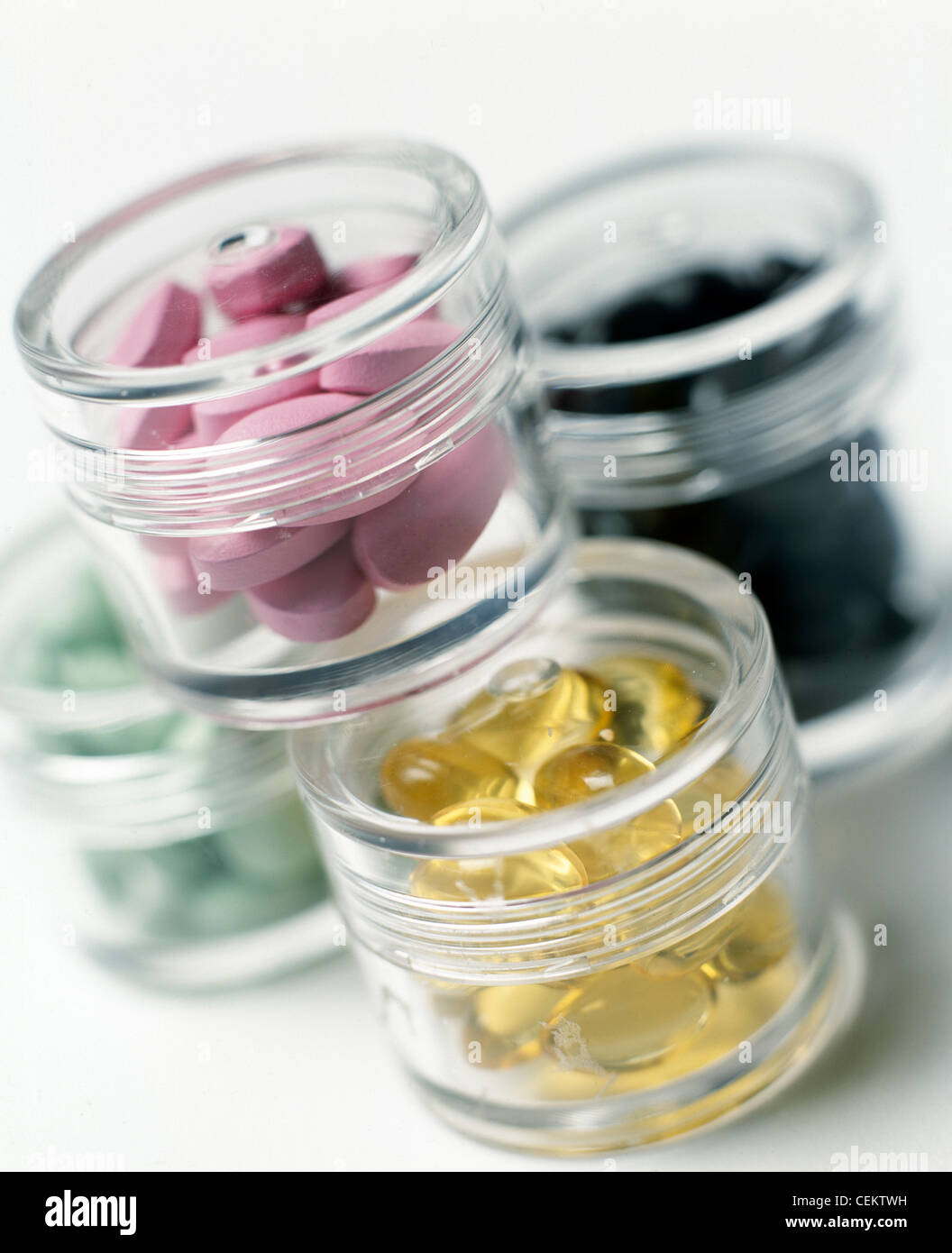 Various tablets and liquid capsules in small clear jars Stock Photo - Alamy