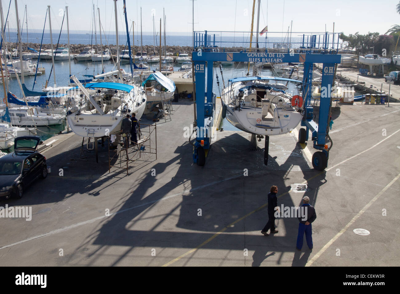 Men workers boats yard maintenance area on Cala Nova port yacht club ...