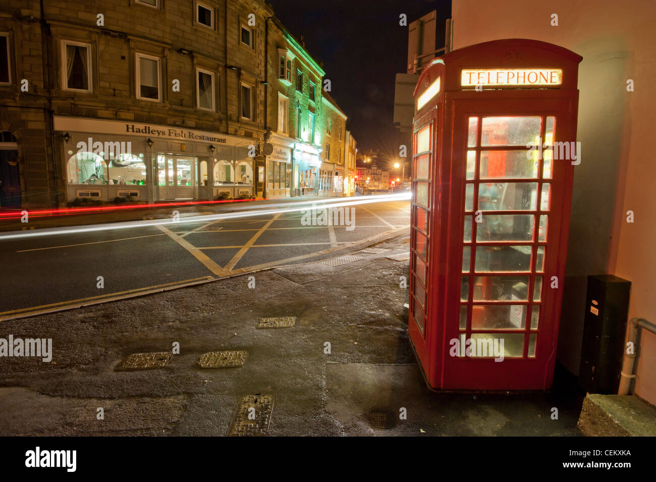 Traditional red public telephone box on street corner in Whitby North ...
