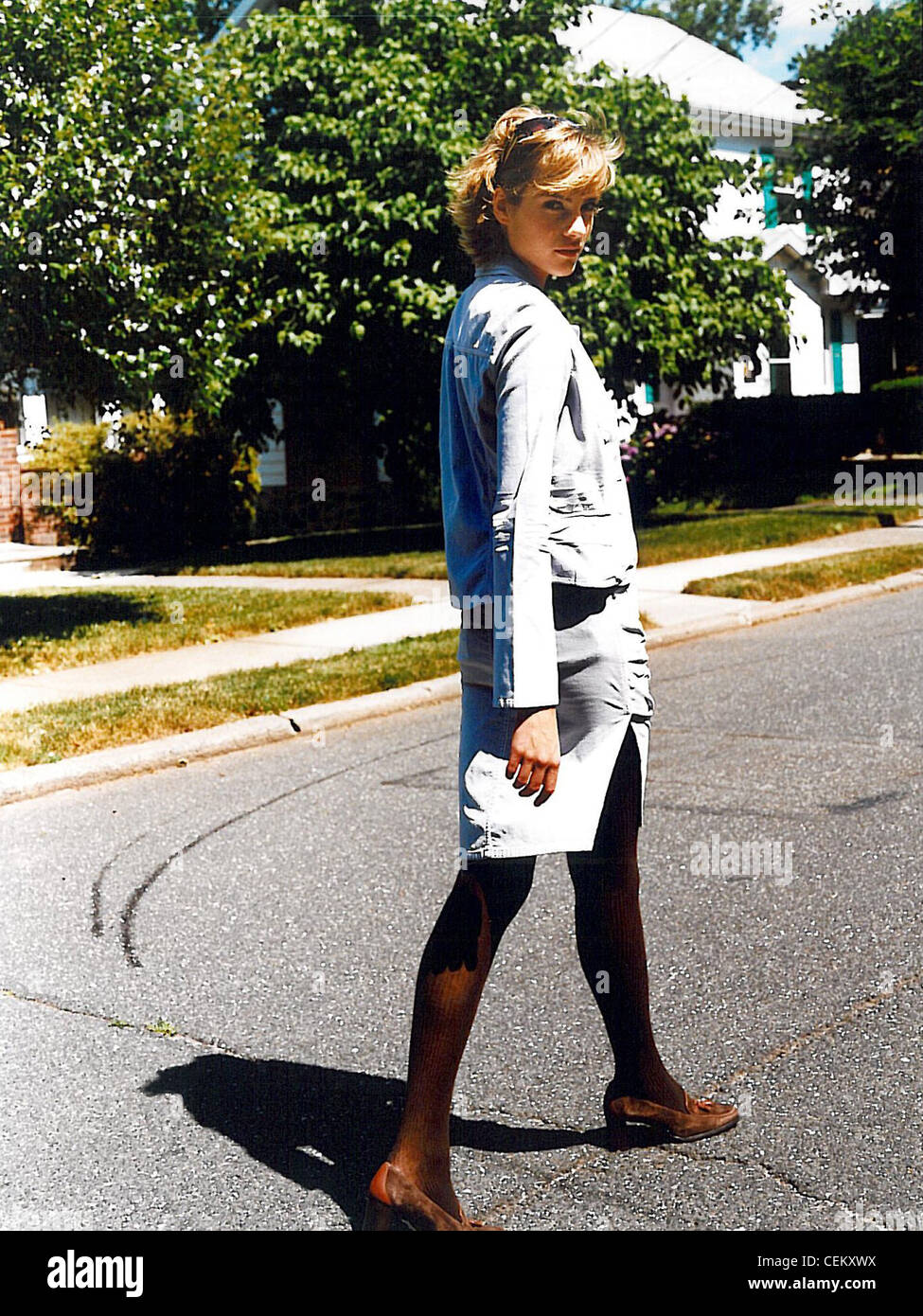 Female walking in road looking over shoulder Frowein Stock Photo - Alamy