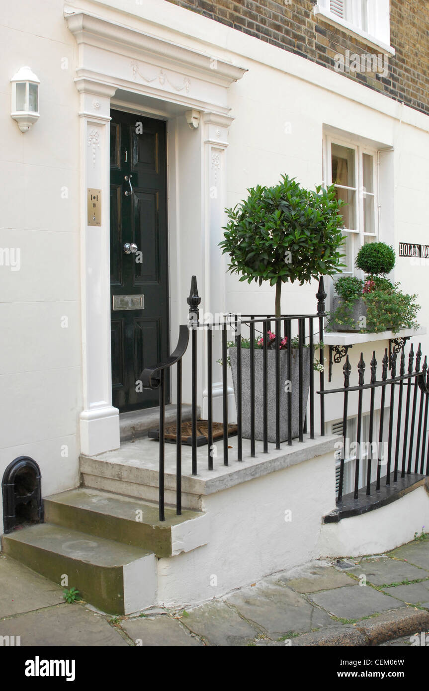 A traditional black front dowith white pediment, stone steps up to ...