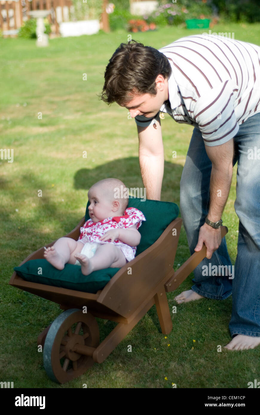 A female baby dressed in a red sleeveless dress white flowers, sitting ...