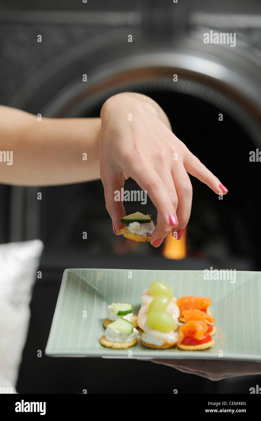 Female hand taking canapes from green plate Stock Photo - Alamy