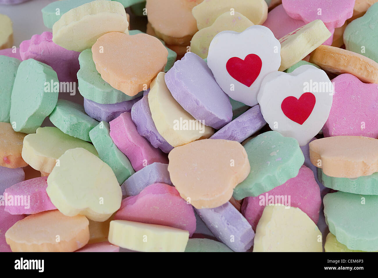 Standing Out in the Crowd. A pile of candy hearts in pastel colors with ...