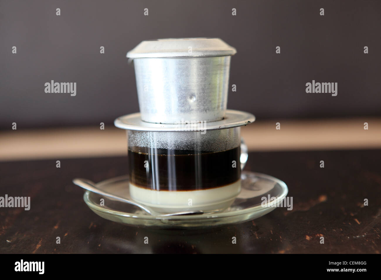 Vietnam coffee dripping through filter into glass at a Phnom Penh cafe ...