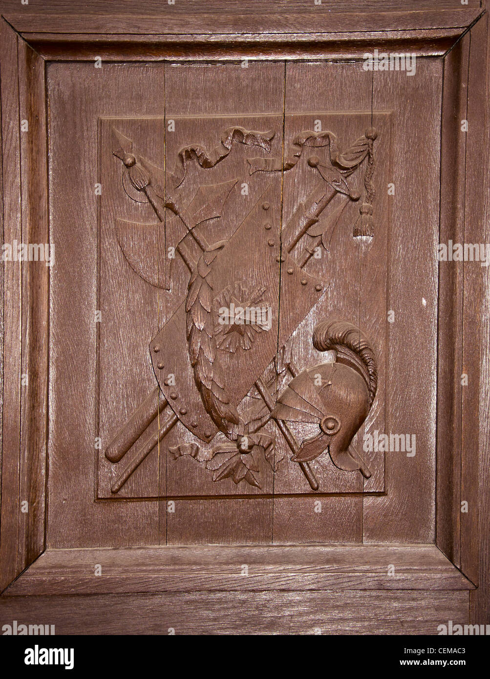 Brown wooden carved palace door with a coat of arms. The helmet shield ...
