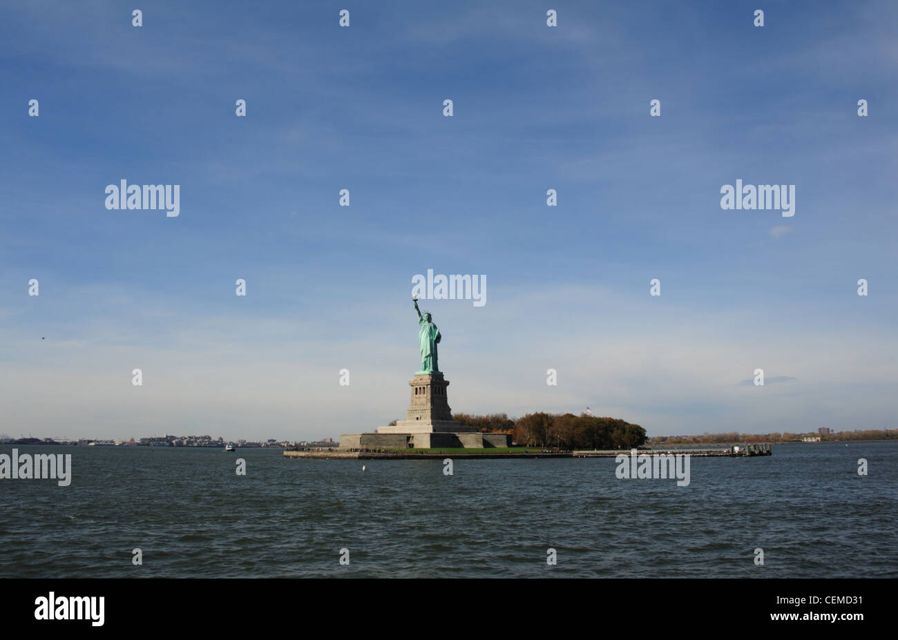 Blue sky autumn view Liberty Island and Statue of Liberty rising above ...