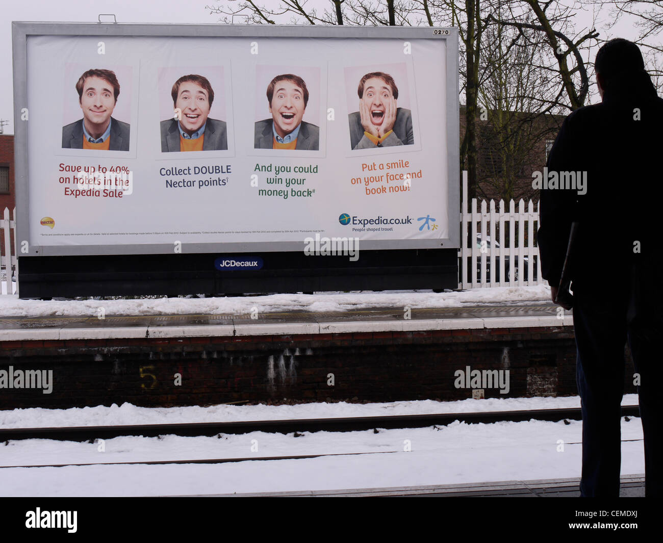 Passenger looks at Expedia holiday advert on a JC Decaux billboard ...