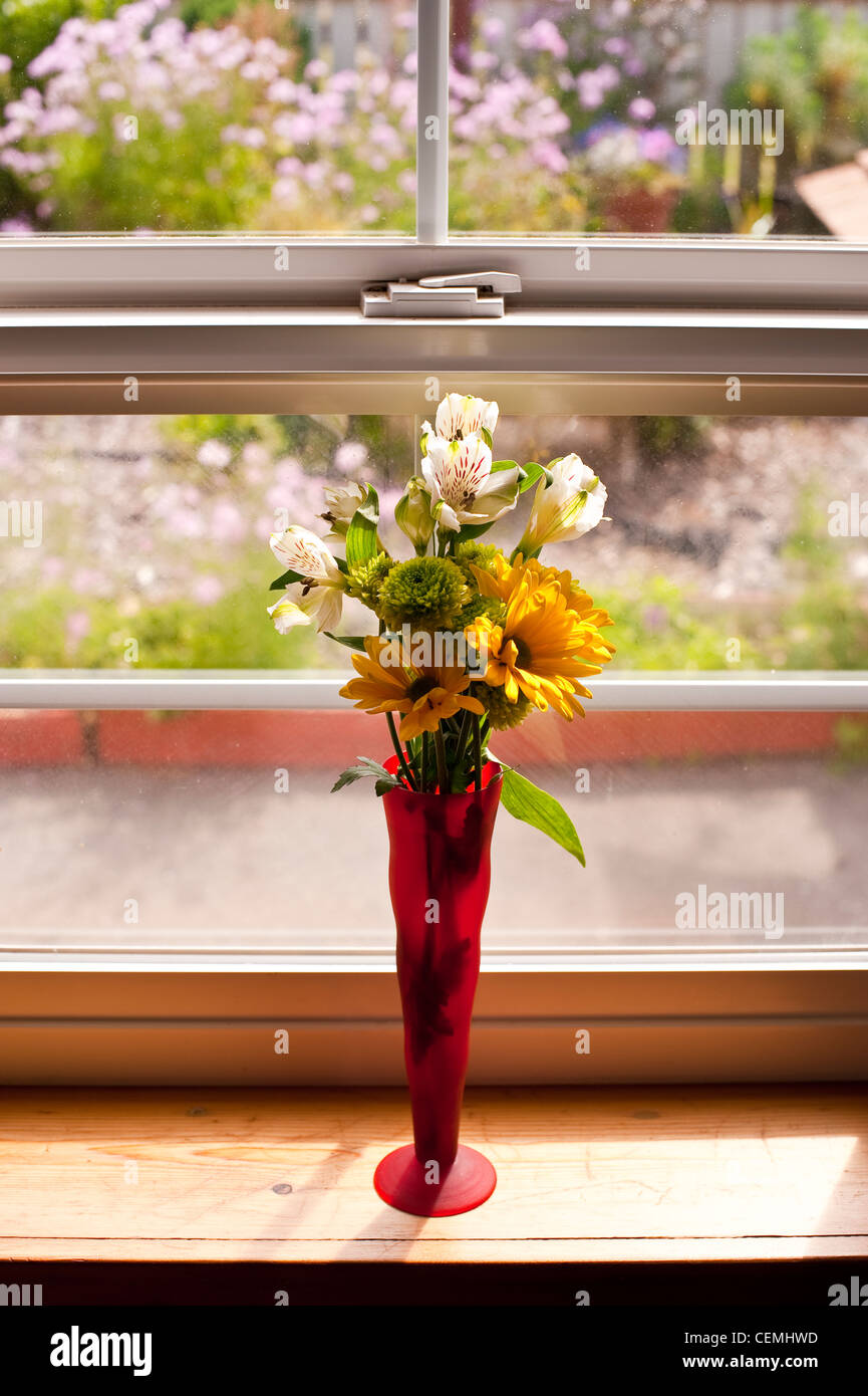 Flower arrangement in vase on window sill with garden Stock Photo - Alamy