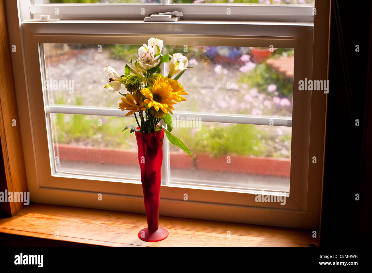 Flower arrangement in vase on window sill with garden Stock Photo - Alamy