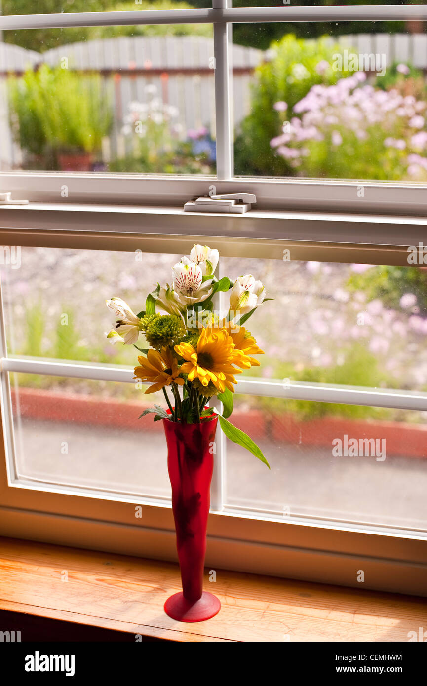 Flower arrangement in vase on window sill with garden Stock Photo - Alamy