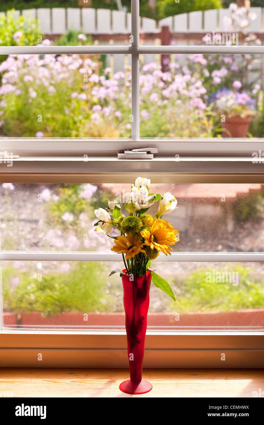 Flower arrangement in vase on window sill with garden Stock Photo - Alamy