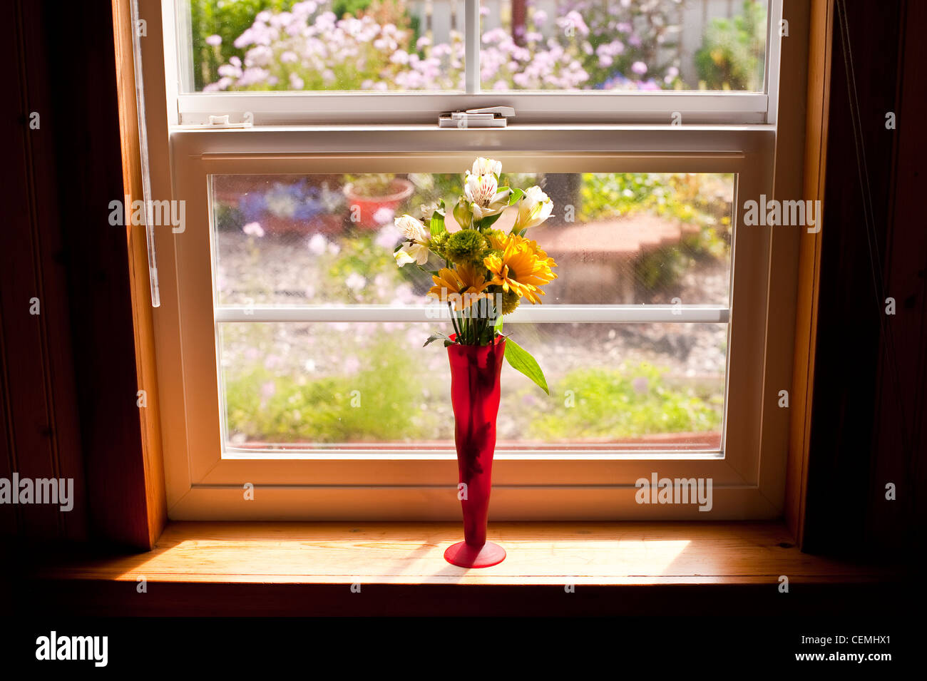 Flower arrangement in vase on window sill with garden Stock Photo - Alamy