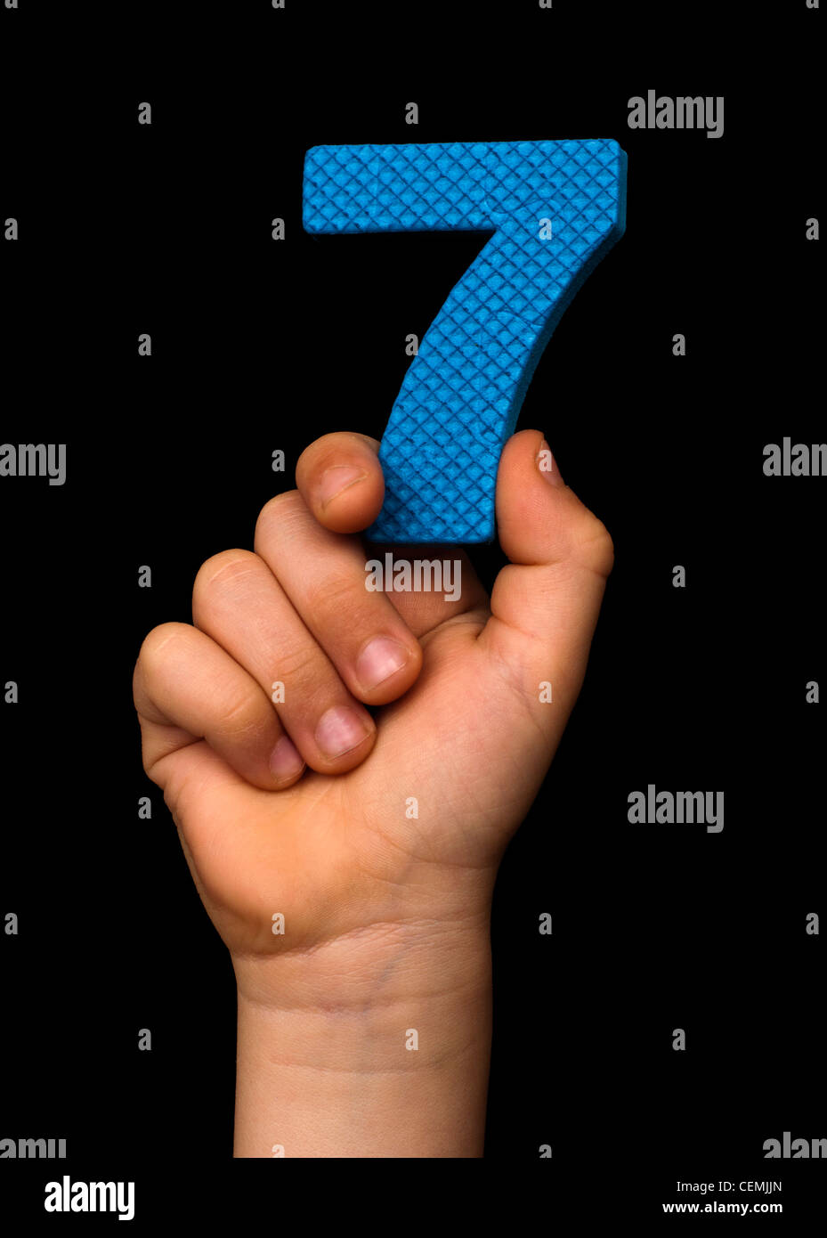Children hand holding the number Seven. Black isolated blue color ...