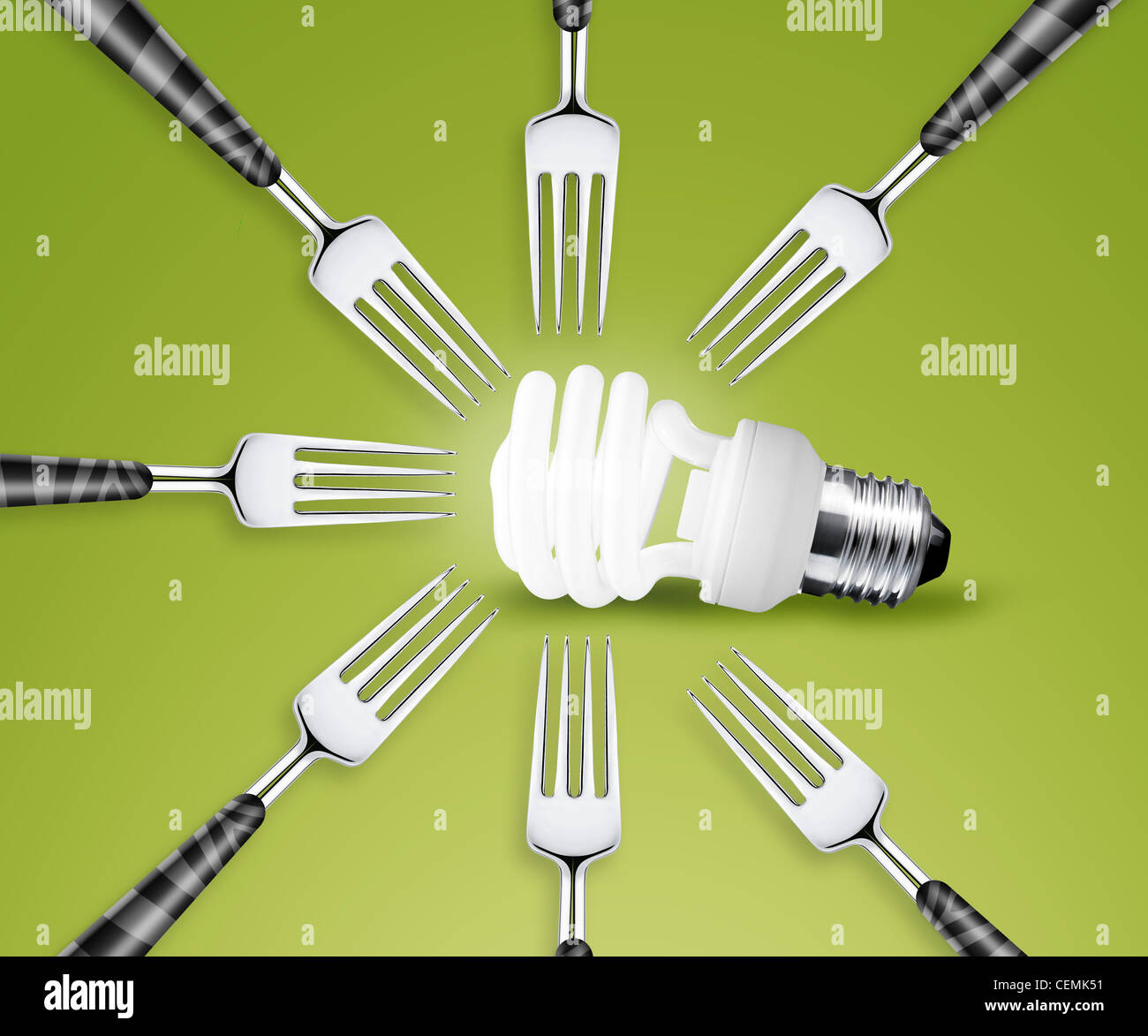 Forks around light bulb, on green background Stock Photo - Alamy