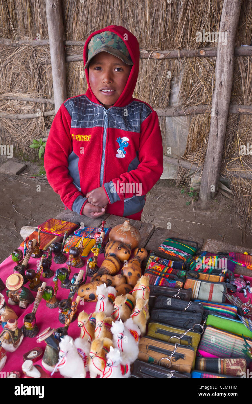 An eight year old Ecuadorian Indian boy sells handmade crafts for ...