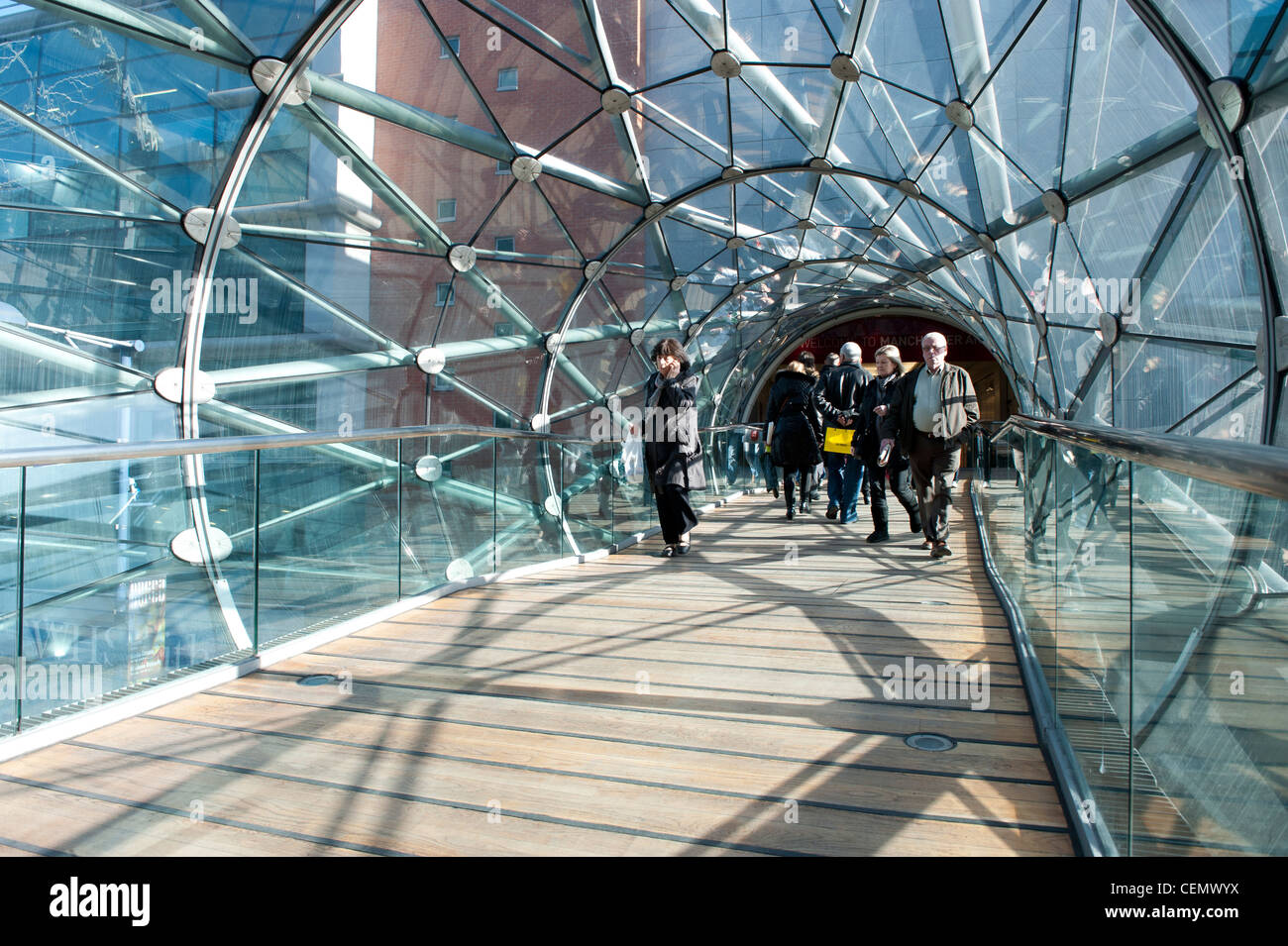 Shoppers walk through glass tunnel connecting Manchester Arndale centre ...