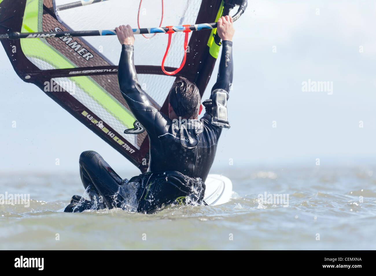 windsurfer struggles out of the water to an upright position and back ...