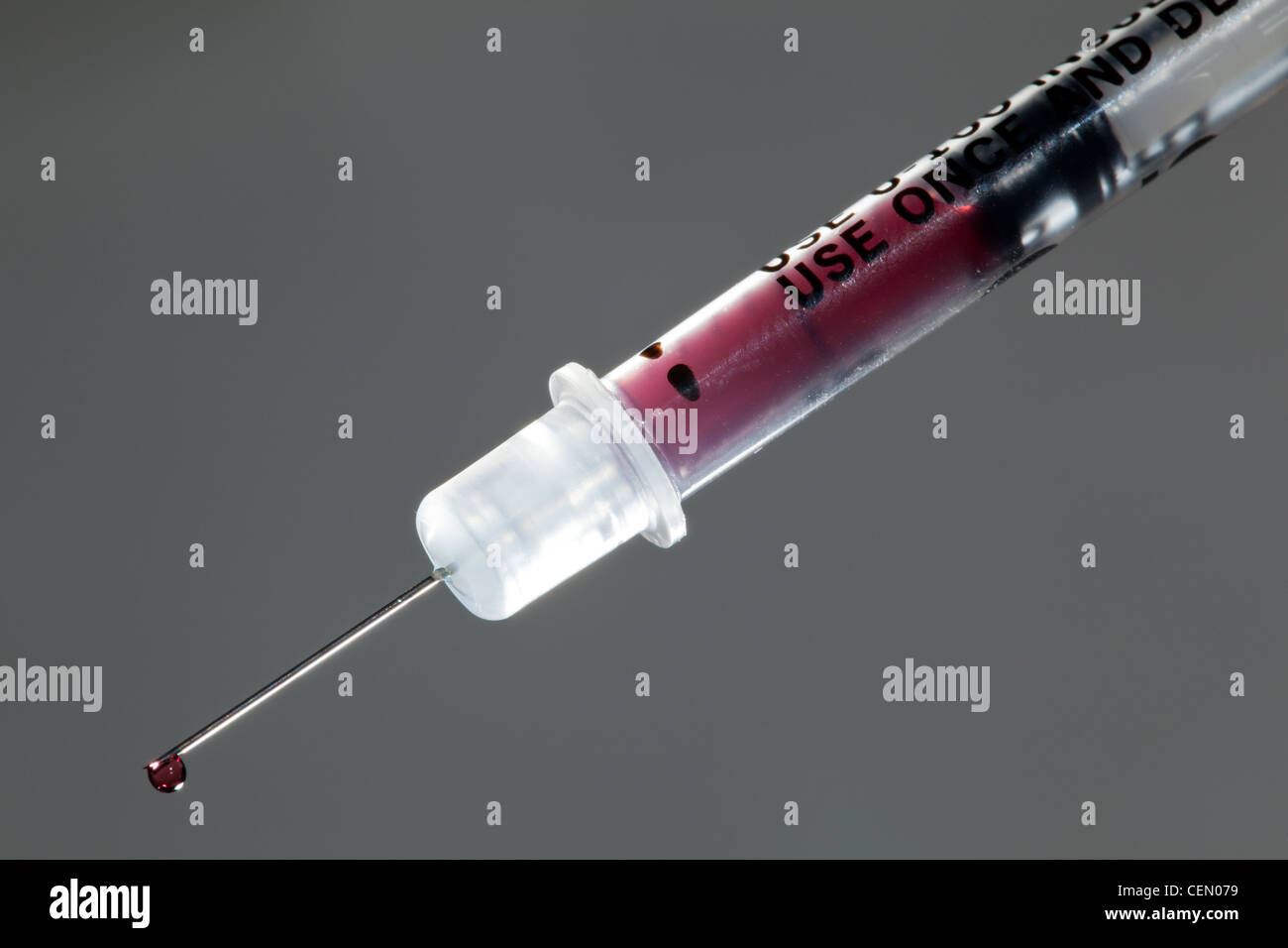 Macro of a drop of blood on the end of a hypodermic syringe needle ...