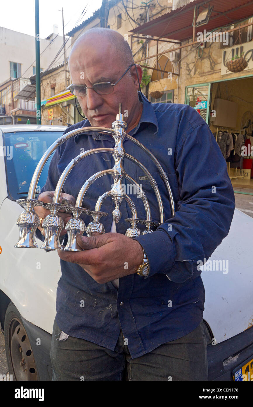 Local merchant polishes a Jewish menorah (used in Hanukkah celebrations ...