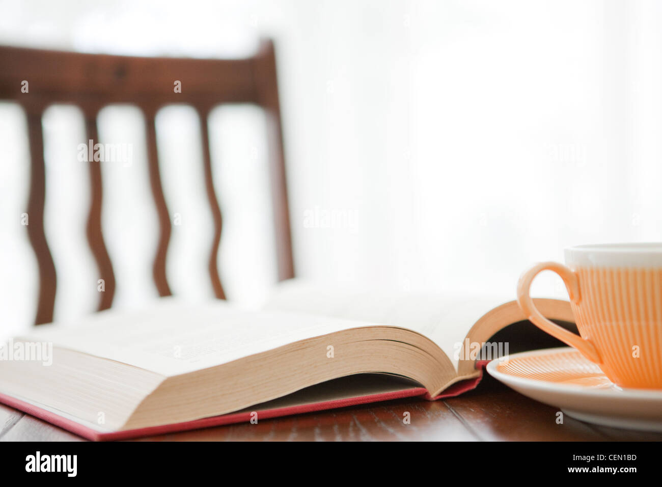Book and cup on the table Stock Photo - Alamy