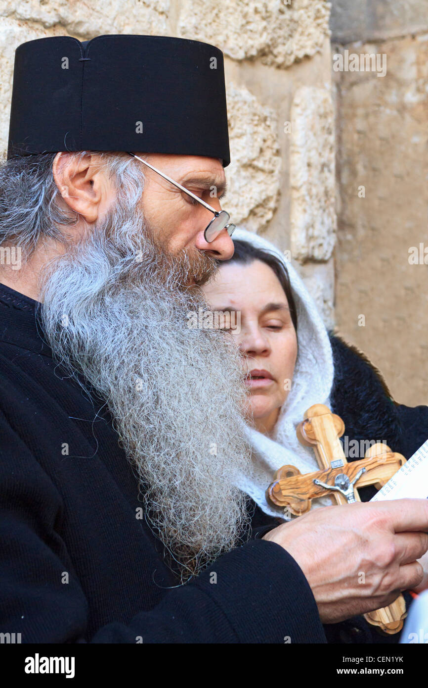 Greek Orthodox priest leads faithful people in prayer at the Church of ...