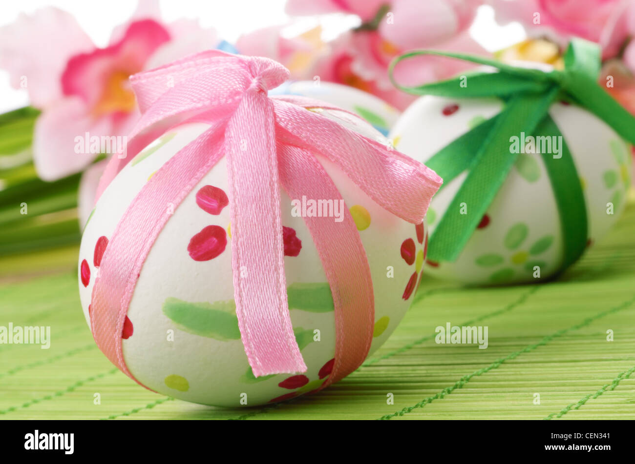 Easter eggs with bows over green background Stock Photo - Alamy
