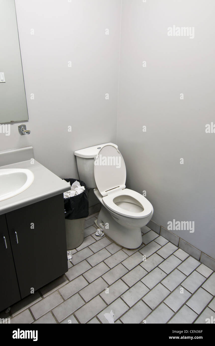 A toilet, sink and waste basket in an office washroom Stock Photo - Alamy