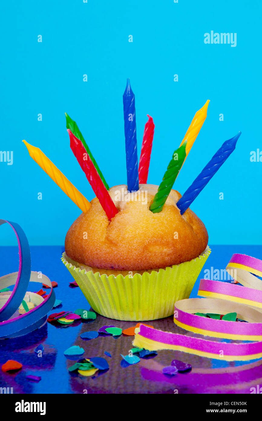 Birthday cupcake with lots of candles, party streamers and colorful ...