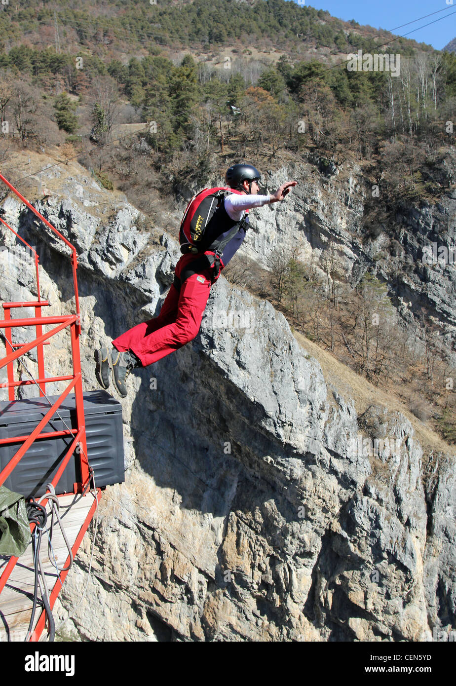 Man is jumping of a black box rack and falling down into the valley. He ...