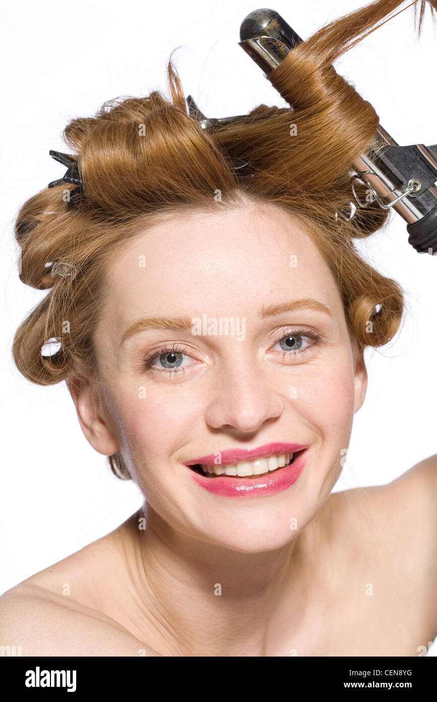 Female long fair hair wrapped on hair curlers and one hair lock wrapped ...