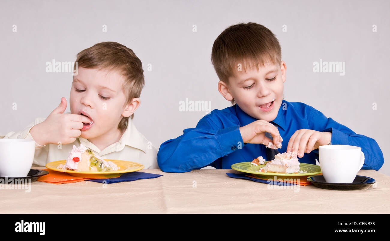 two boys eating a cake his hands Stock Photo - Alamy
