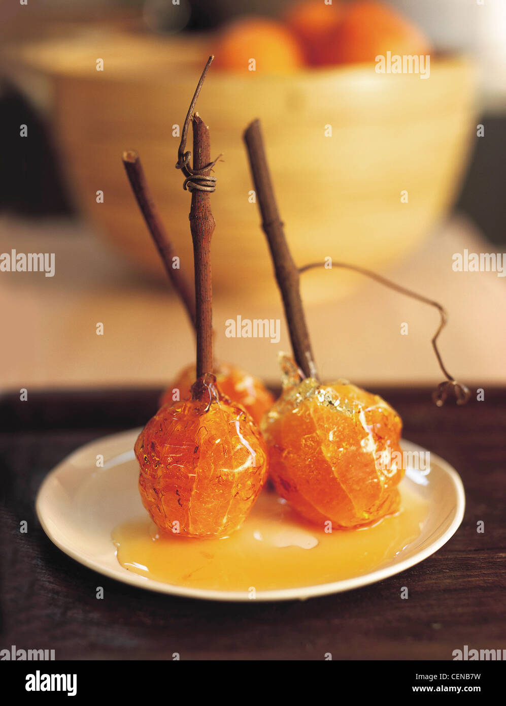 'MODERN ZEST' Toffee apples in syrup on sticks on white plate Stock ...