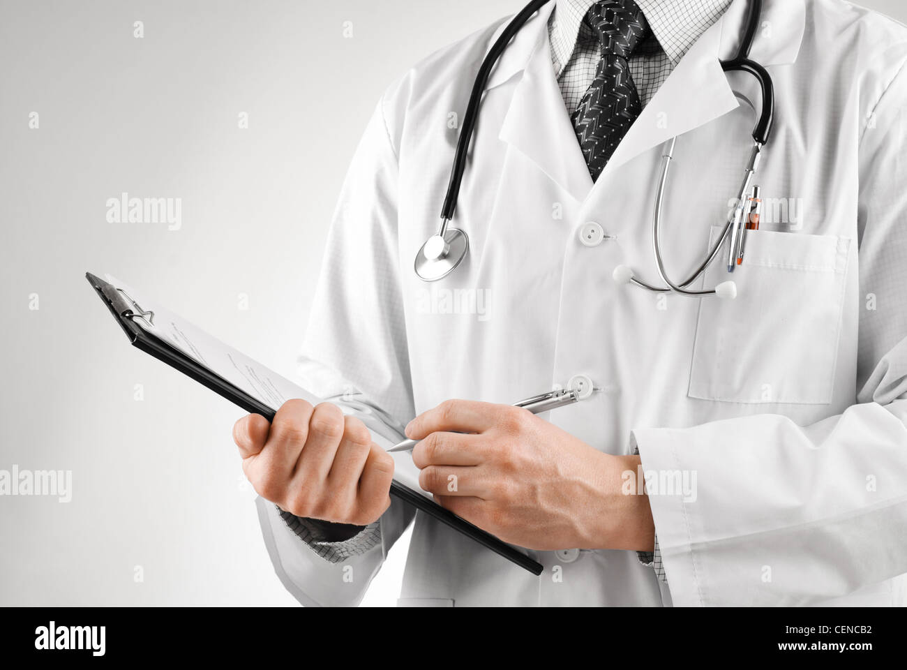 Doctor with stethoscope writing something on clip board Stock Photo - Alamy