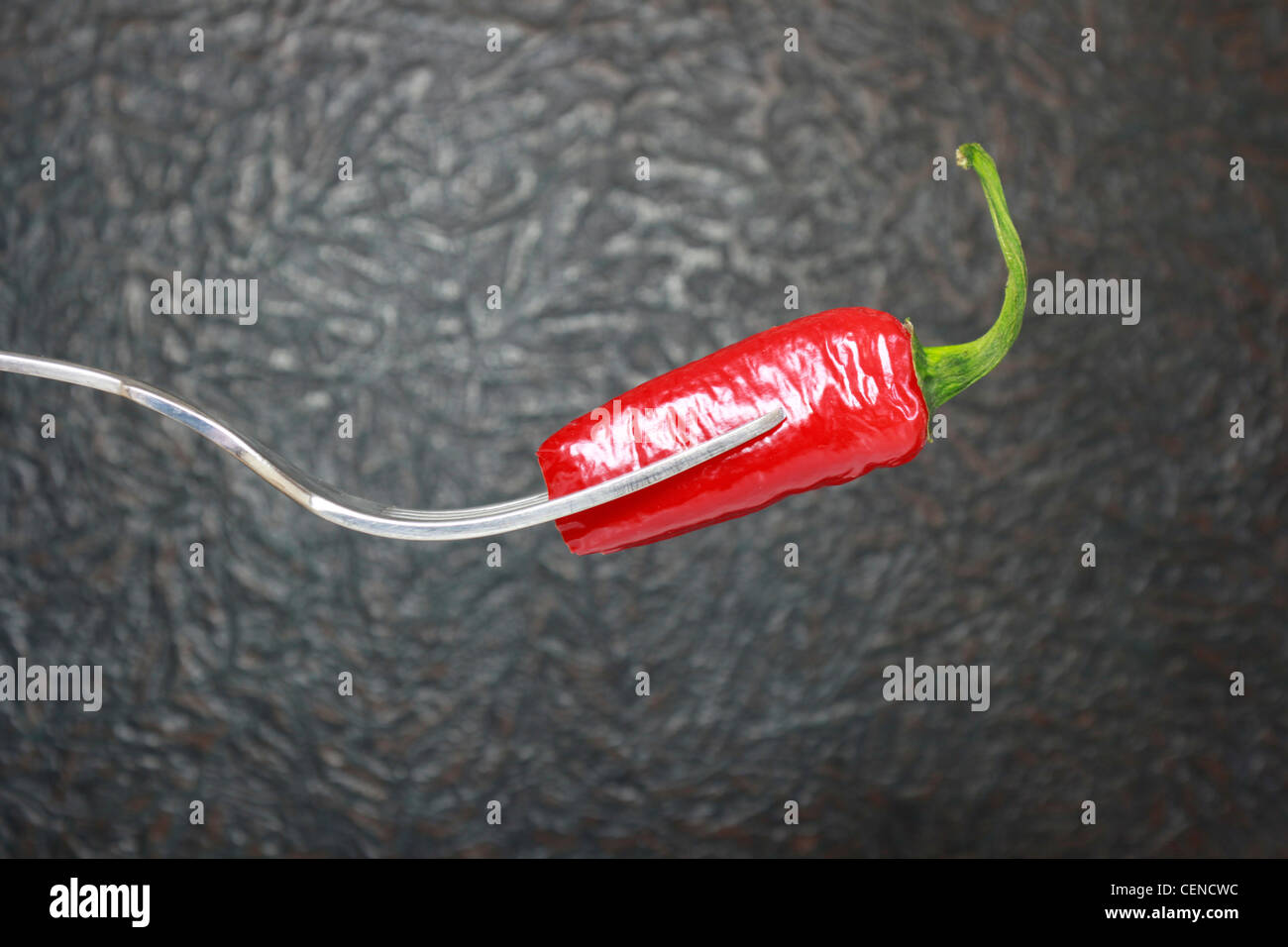 Steel fork with a hot chili Stock Photo - Alamy