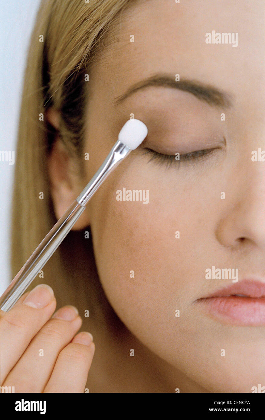 Close up of half face of female long straight blonde hair tucked behind ...