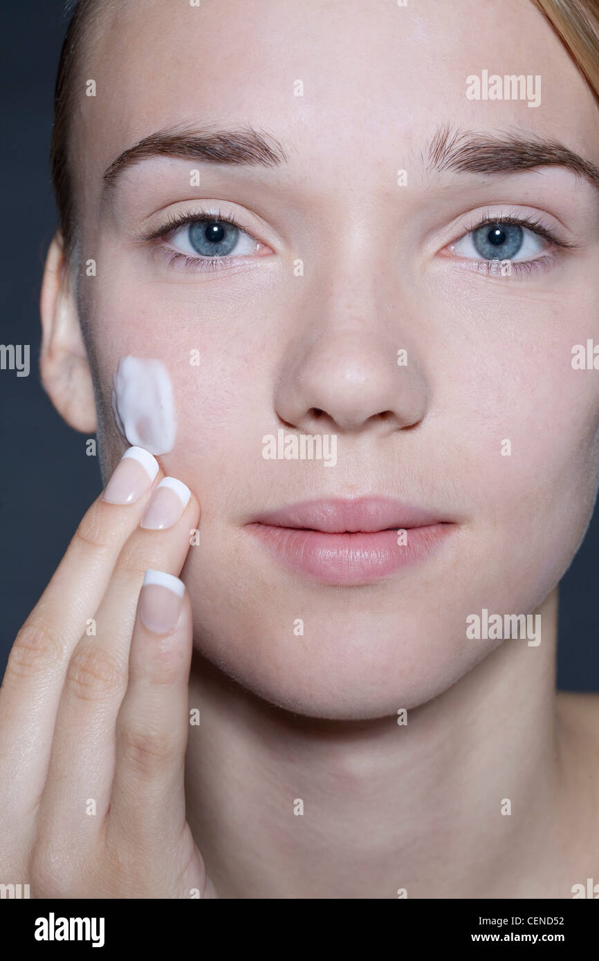Step by Step Beauty and Make Up Female applying face cream to her cheek ...