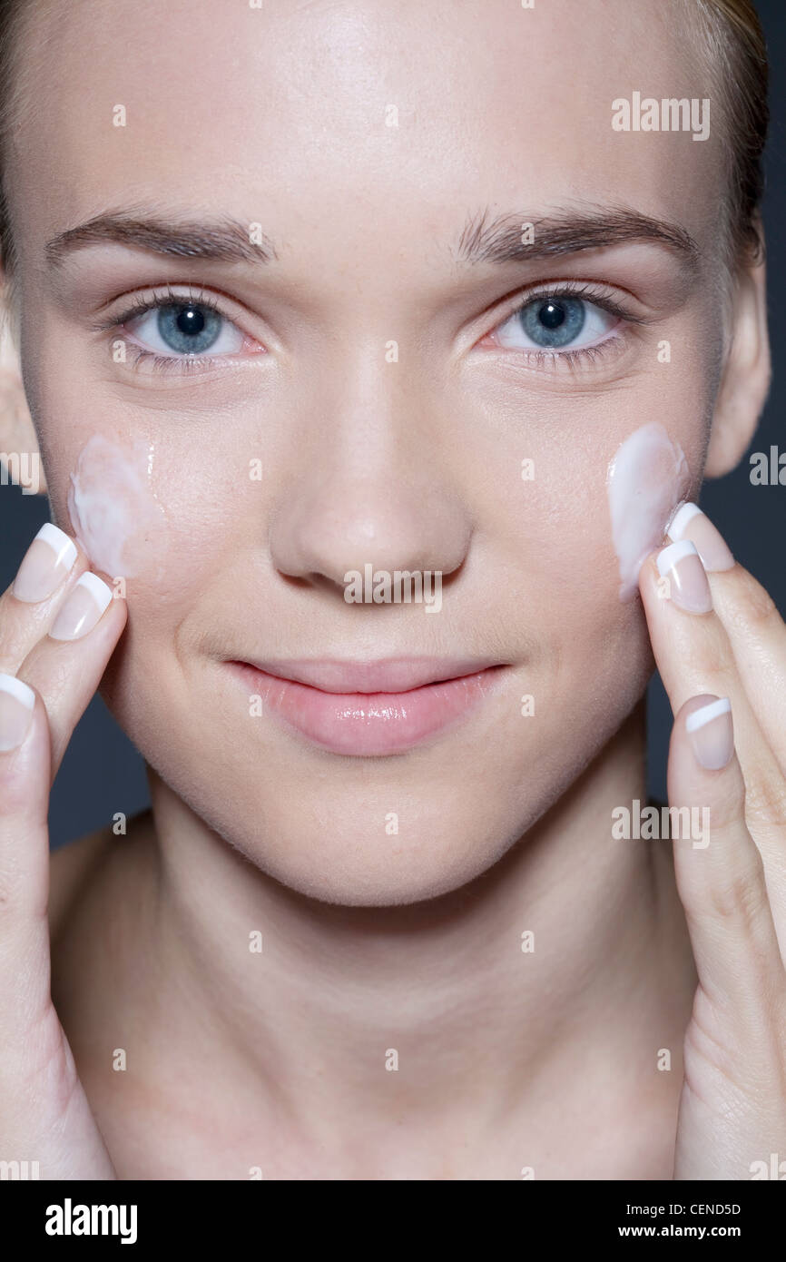 Step by Step Beauty and Make Up Female applying face cream to her cheek ...