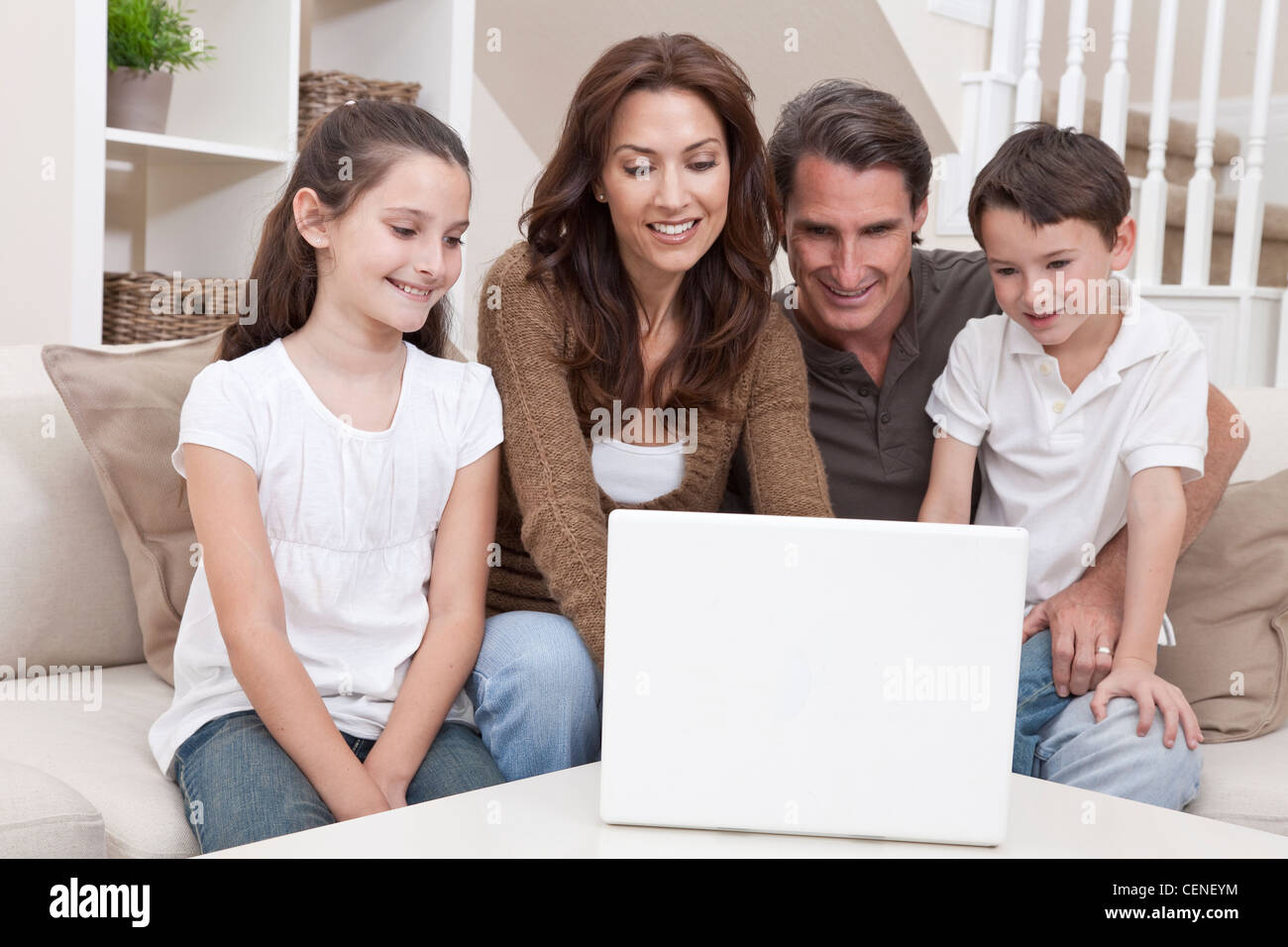 Happy family, parents, son and daughter, having fun using laptop ...